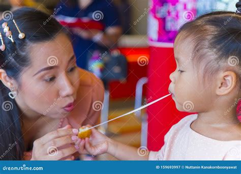 Mamãe E Criança Comendo Uma Bola De Queijo Frito E Pegajosa Prazer Imagem de Stock Imagem de