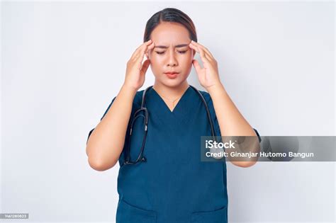 청진기로 파란색 유니폼을 입고 피곤한 젊은 아시아 여성 간호사가 아프고 머리를 만지고 흰색 배경에 고립된 두통이 있습니다 의료 의학 개념 간호사에 대한 스톡 사진 및 기타