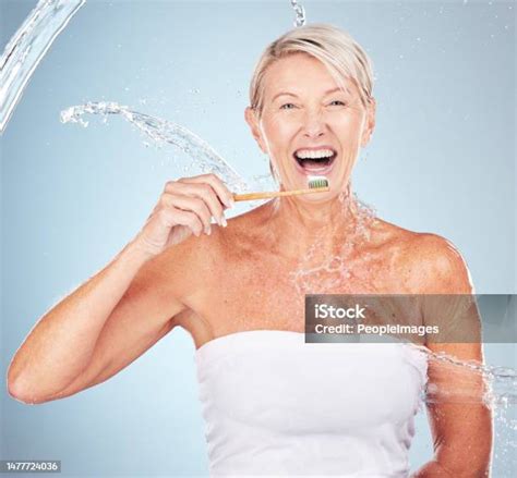 여자 스튜디오 칫솔에 물이 튀고 미소를 짓거나 파란색 배경으로 입 건강을 위한 초상화 행복한 시니어 모델 유기농 나무 브러시 또는 자기 관리 과정에서 건강한 치아를 위한