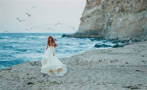 Обои на рабочий стол Девушка в белом платье стоит на фоне моря фотограф Marina Monaco обои для