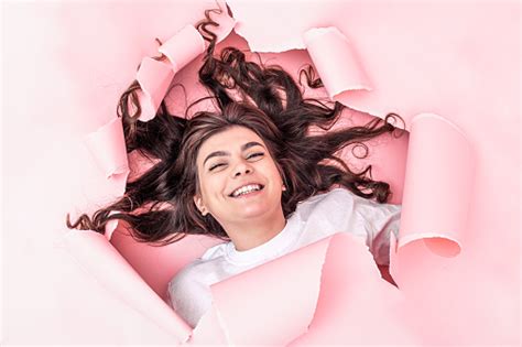 재미있는 소녀가 분홍색 배경의 종이 구멍을 들여다 보입니다 구멍에 대한 스톡 사진 및 기타 이미지 구멍 떠남 자신감 Istock