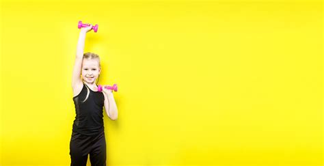 테마 스포츠와 건강 미소와 노란 배경에 포즈 웬과 아름 다운 백인 아이 소녀 분홍색 덤 벨을 들고 있는 작은 운동 선수 광고 배너 텍스트 복사 공간 공간 가냘픈에 대한 스톡