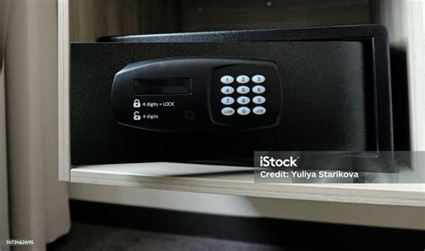옷장에 있는 금속 금고 호텔에 돈이나 귀중품을 보관할 수있는 작은 좁은 금고 비우기 비밀번호 입력 버튼이 있는 안전한 문을 엽니다 캐비닛 내부의 소형 금고 선택적 초점 0