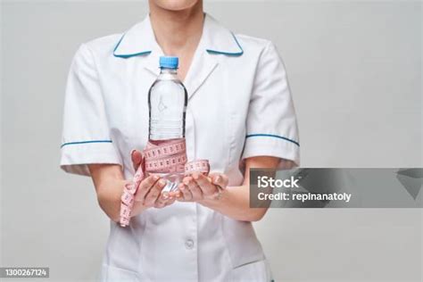 젊은 백인 여성 건강 관리 전문가의 초상화물 병 들고 물 과 측정 테이프 빛 회색 배경 위에 서 30 34세에 대한 스톡 사진 및 기타 이미지 Istock