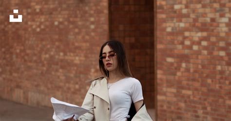 흰 셔츠와 검은 바지를 입은 여자가 종이 한 장을 들고 있다 사진 Unsplash의 무료 이스파한 주 이미지