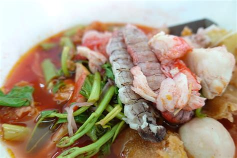 Yentafo 매운 국수 수프 뜨겁고 매운 혼합 해산물 가재 새우와 함께 테이블 배경에 흰색 그릇에 아시아 매운 해산물 국수 수프 태국 스타일의 국수와 태국의 길거리 음식