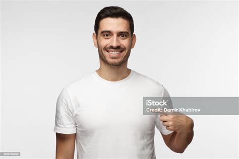 회색 배경에 고립 된 광고 텍스트 또는 이미지 서 빈 공간을 가진 빈 흰색 티셔츠에 검지 손가락으로 가리키는 젊은 남자 T 셔츠에 대한 스톡 사진 및 기타 이미지 Istock