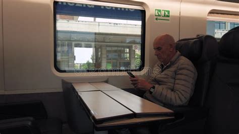 Old Senior Waiting For His Train To Leave And Looking At His Phone