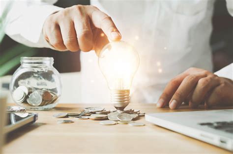 돈 금융 계획을위한 메모와 함께 책상에 쌓인 동전에 전구를 들고있는 사업가 돈을 절약하고 돈을 절약하는 개념은 돈 동전 스택을 성장 비즈니스 개념을 넣어 개념에 대한 스톡