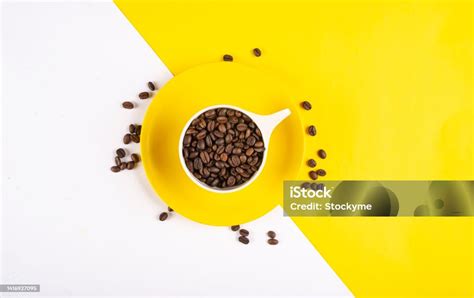 노란색과 흰색 배경에 콩으로 가득 찬 커피 컵의 상단 전망 노랑에 대한 스톡 사진 및 기타 이미지 노랑 뜨거운 음료 머그