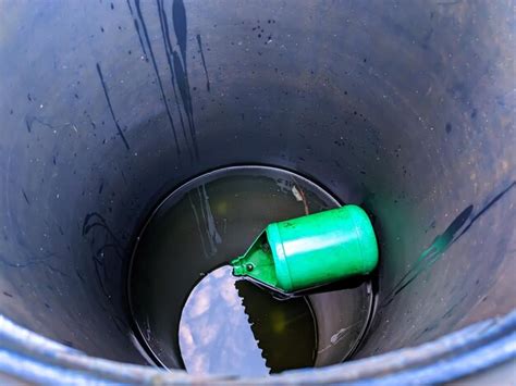 Premium Photo A Green Container That Is In A Blue Barrel Containing Water