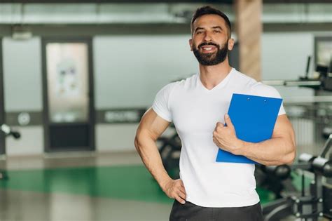 Premium Photo Portrait Of Personal Trainer Holding Clipboard With