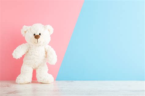 밝은 분홍색 파란색 벽 배경에 나무 바닥에 서 흰색 테디 베어 미소 파스텔 색상 영감 감정적 감상적인 텍스트 인용 또는 말을위한 빈 장소 근접 촬영 전면 보기입니다 봉제