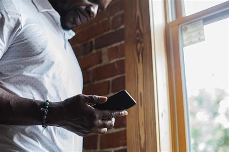 창문 옆에 서서 스마트 폰에서 문자 메시지를 읽는 사람의 샷을 잘라냅니다 40 44세에 대한 스톡 사진 및 기타 이미지 40 44세 거실 긍정적인 감정 표현 Istock