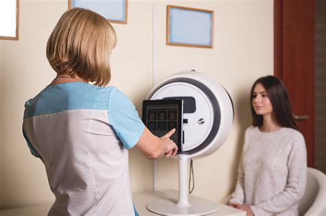 전문 미용 장비를 사용하여 전체 얼굴 피부 분석을 얻는 여성의 클로즈업 아름다운 젊은 여성은 디지털 진단을 수행합니다 화장품 및 피부과 개념 건강관리와 의술에 대한 스톡