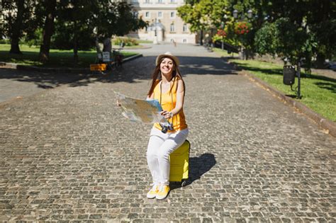 즐거운 여행자 관광 여자 노란색 옷 모자 야외 시에서 도시 지도 검색 경로 들고 가방에 앉아 여자도 주 주말에 여행을 해외 여행입니다 관광 여행 생활양식입니다