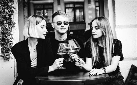 Premium Photo Young Woman Sitting On Table With People In Background