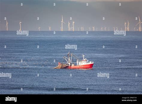 A Cutter With Lifted Drag Nets On The North Sea With Wind Turbines In