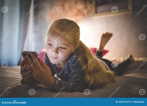 Beautiful Blonde Haired Girl Laying On Her Bed Watching Videos On A