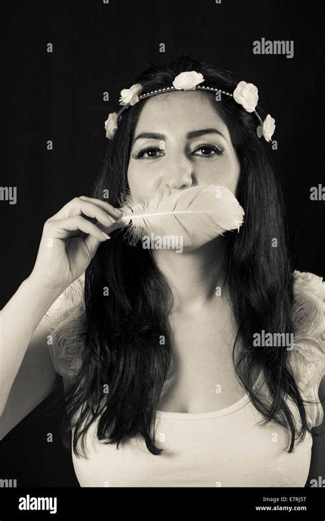 Romantic Looking Woman With A Tiara Holding A White Feather In Front Of