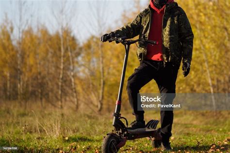 한 젊은이가 가을 숲이나 공원을 통해 전기 스쿠터를 탄다 화창한 가을 날 현대 도시 교통 25 29세에 대한 스톡 사진 및 기타