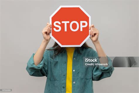 정지 기호 뒤에 얼굴을 숨기고 있는 알 수 없는 사람 접근 제한에 대한 빨간색 교통 표지판 경고 20 24세에 대한 스톡 사진