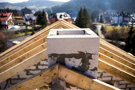 흐린 녹색 배경에 거품 절연 블록으로 만든 거친 목재 목재 빔과 굴뚝의 지붕 프레임의 클로즈업 세부 사항 건축 지붕 건설 및 리노베이션 컨셉 개발에 대한 스톡 사진 및 기타