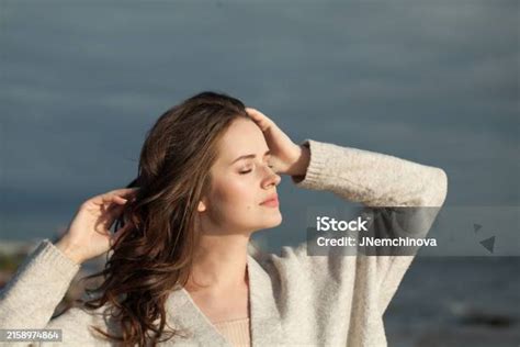 세련된 아가씨 갈색 머리 모델 바다 해변 야외에서 화장을 하고 긴 짙은 물결 모양의 헤어스타일을 하는 아름다움 여자 평온함 감정 기분 여행 계절 및 휴가 개념 25 29세에