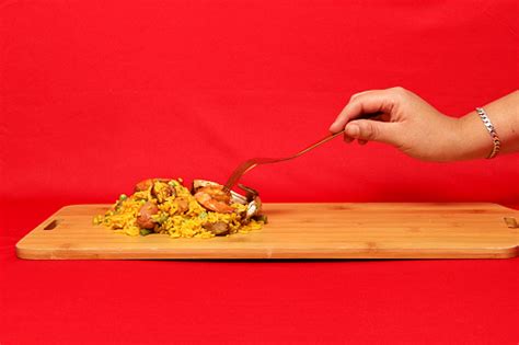 사프란 조개류 새우 야채로 만든 발렌시아 스페인의 전통 빠에야 쌀은 나무 판에 담겨 있고 흰색 배경에 포크를 가져 오는 손 0명에 대한 스톡 사진 및 기타 이미지 Istock