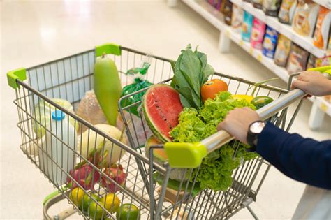 쇼핑 카트 또는 트롤리와 식료품 제품 선반에 슈퍼마켓에서 과일과 야채를 구입 하는 여자 손 상점에서 음식 사람들의 라이프 스타일