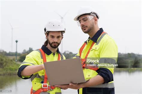 풍차 현장 농장에서 노트북 컴퓨터를 사용하여 안전 유니폼을 입고 풍력 터빈의 품질 검사 및 검사 풍력 터빈 수리 또는 유지 보수를 하는 남성 엔지니어 20 24세에 대한