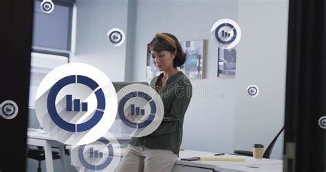 Image Of Multiple Bar Graph Icons Floating Over Asian Woman Using Laptop At Office Stock Image