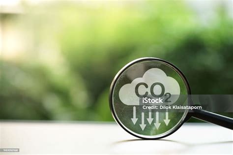 Co2 감소를 위한 녹지 배경의 돋보기 유리 내부의 Co2 감소 아이콘 탄소 발자국 및 탄소 배출권은 기후 변화로 인한 지구
