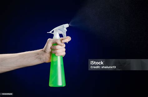 청소기 테마 고 집 청소 남자의 손을 잡고 스튜디오에 진한 파란색 배경에 청소에 대 한 녹색 스프레이 병 가사 집안일에 대한 스톡 사진 및 기타 이미지 Istock