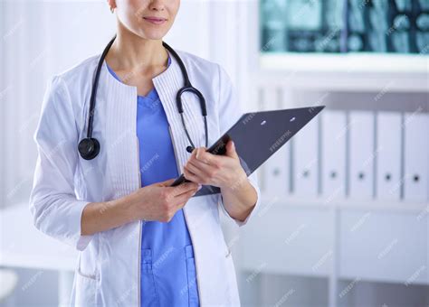 Jeune Femme Médecin Souriante Avec Stéthoscope Tenant Un Dossier Au