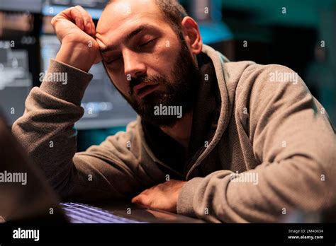 Tired Male Programmer Falling Asleep At Office Desk Working On Interface Programming Holding