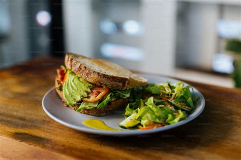 접시에 양상추와 토마토를 곁들인 샌드위치 사진 Unsplash의 구운 샌드위치 이미지