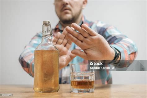 술을 거부하는 남자 술이 담긴 잔 테이블 위의 위스키 또는 브랜디 한 병 알코올 중독과 나쁜 습관 개념 30 34세에 대한 스톡 사진 및 기타 이미지 Istock