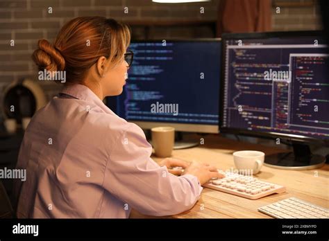 Female Programmer Working With Computer In Office At Night Stock Photo