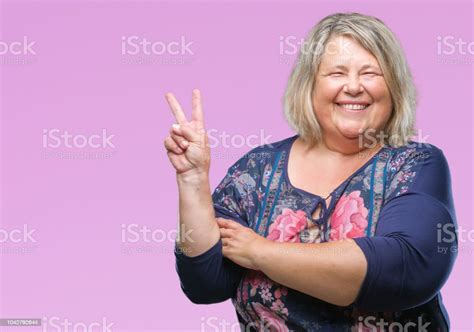 시 니 어 플러스 크기 이상의 백인 여자 절연 배경 승리를 하 고 카메라에 윙크 하는 행복 한 얼굴로 웃 고 로그인 합니다 번호 2입니다 과체중에 대한 스톡 사진 및 기타