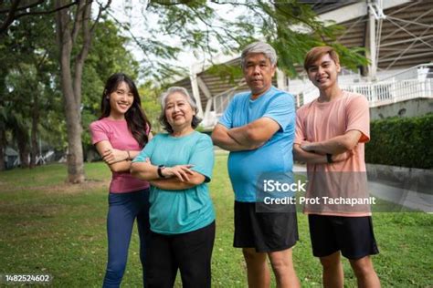 건강한 가족 그룹 강사는 신선한 공기 속에서 운동을하고 공원에서 아침 운동 후 휴식을 취하고 함께 서 있습니다 야외 활동 건강한 생활 방식 튼튼한 몸매 몸매 건강 관리