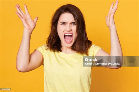 울고 감정적인 젊은 여성 걸쇠 손과 카메라에서 초조 보이는 네 부 모습을가지고 남편과 충돌 노란색 배경 인간의 감정 얼굴 표정 개념에 대 한 실내 제스처 감정에 대한 스톡