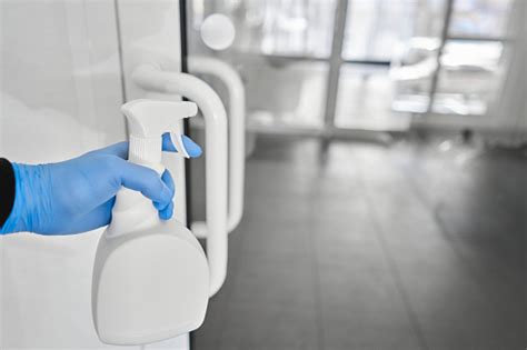 도어 핸들의 소독 청소 및 세척 코비드19 코로나 바이러스 감염의 예방 흰색 병에서 소독제를 살포하여 도어 핸들을 소독하는 클로즈업 살균에 대한 스톡 사진 및 기타 이미지