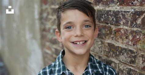 파란색과 흰색 격자 무늬 버튼 업 셔츠를 입은 소년 웃고 있다 사진 Unsplash의 무료 십대 이전 이미지