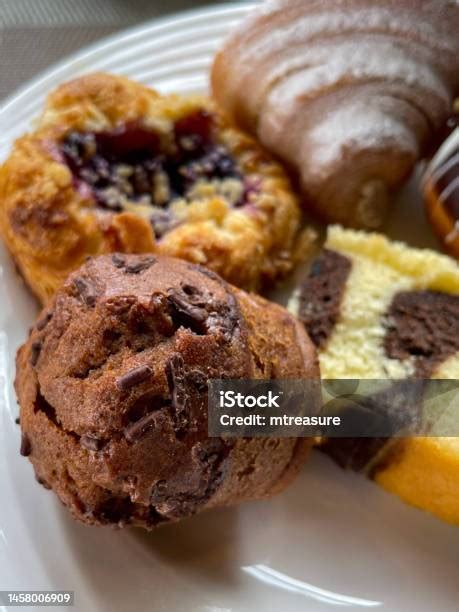 아침 식사 패스트리와 케이크의 흰색 접시 블루 베리 잼 과자 초콜릿과 바닐라 대리석 케이크 조각 초콜릿 머핀 커피 초콜릿 유약 링 도넛 착빙 설탕을 뿌린 크루아상 높은