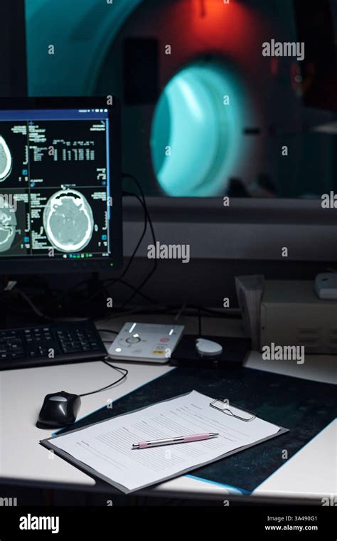 imaging center showing brain scan results on screens and tech equipment on desk medical