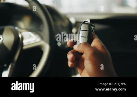 Close Up Of Man Holding Contactless Car Key In Hand And Winding Up Expensive Car Button