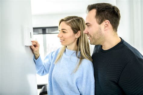 Couple Set The Thermostat At Home House Stock Photo Image Of Interior Caucasian 320212114