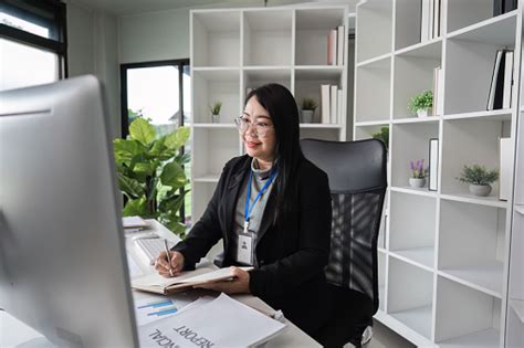 문서와 컴퓨터가 있는 현대적인 사무실 환경에서 일하는 중년 비즈니스 여성 경영자에 대한 스톡 사진 및 기타 이미지 경영자 기업 비즈니스 리더십 Istock