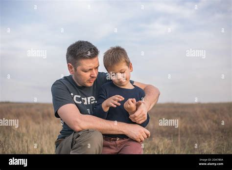 Happy Dad Hugging Son On The Meadow Background Concept Of Father Son